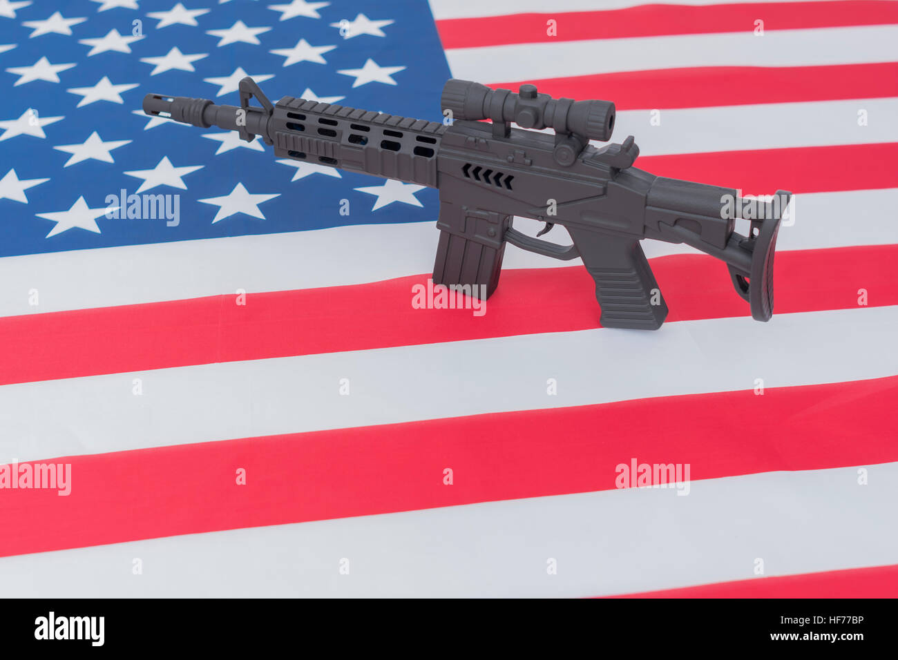 Black toy assault rifle set against US / American flag / Stars ...