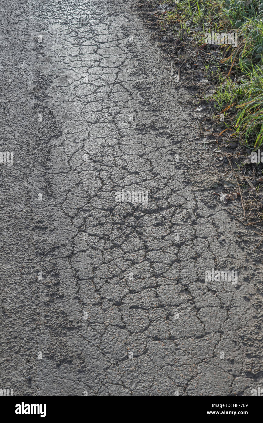 Road frost damage: alligator cracked / crazed tarmac surface of a rural ...