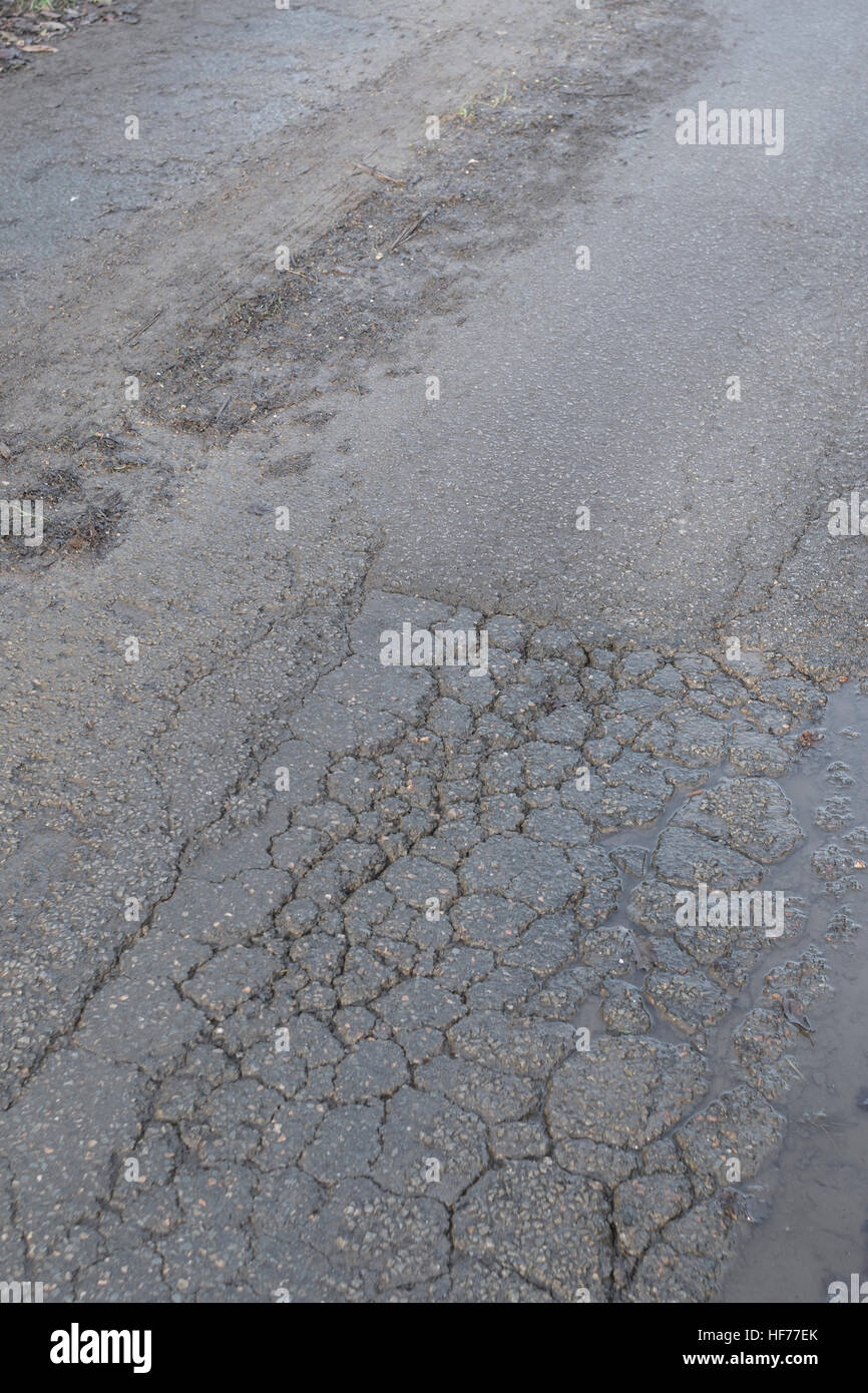 Frost damaged / cracked tarmac surface of a rural / country road in ...