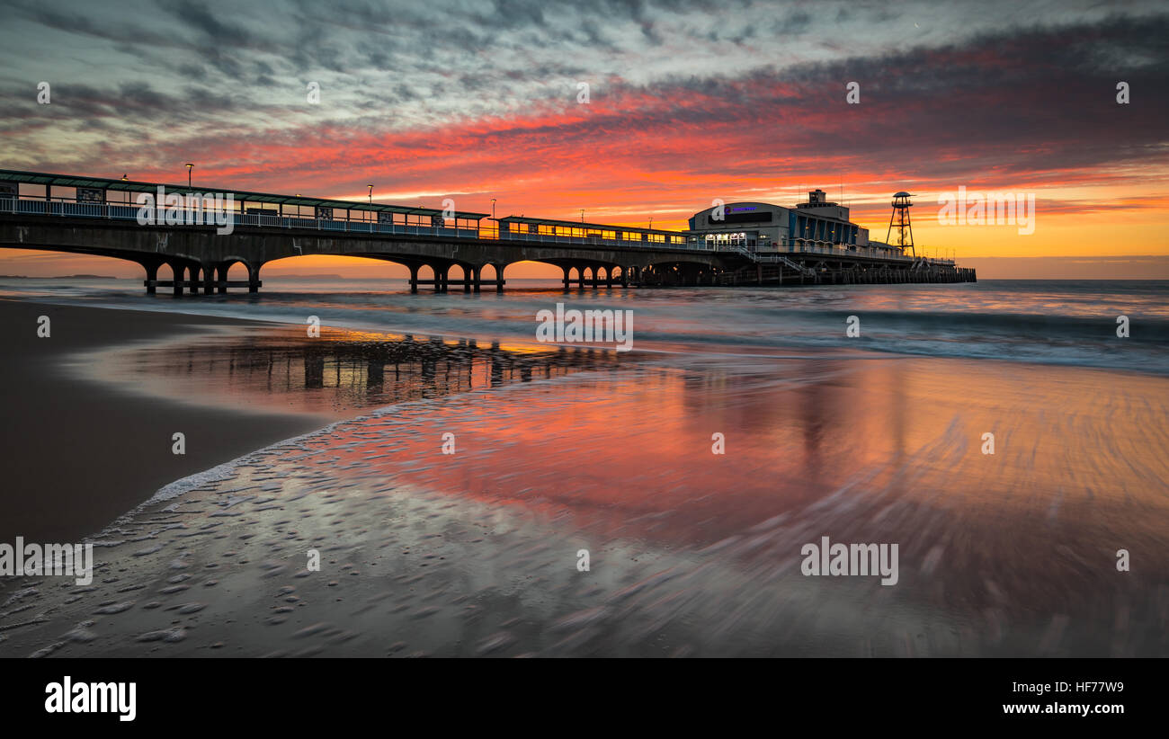 Bournemouth Pier with the sunrise behind and waves rushing in Stock ...