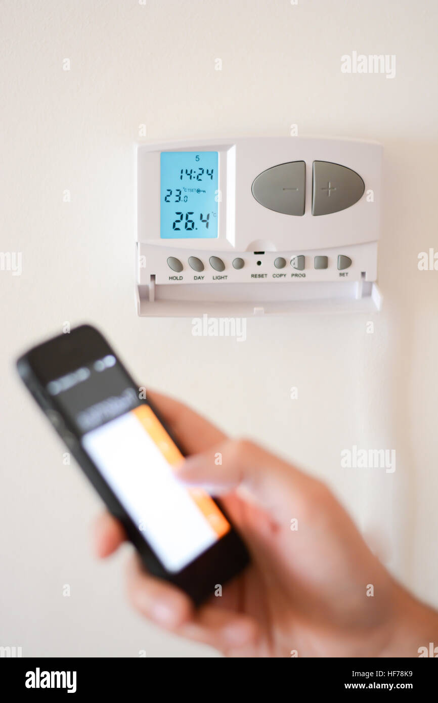 Adjust temperature in home interior with smartphone Stock Photo - Alamy
