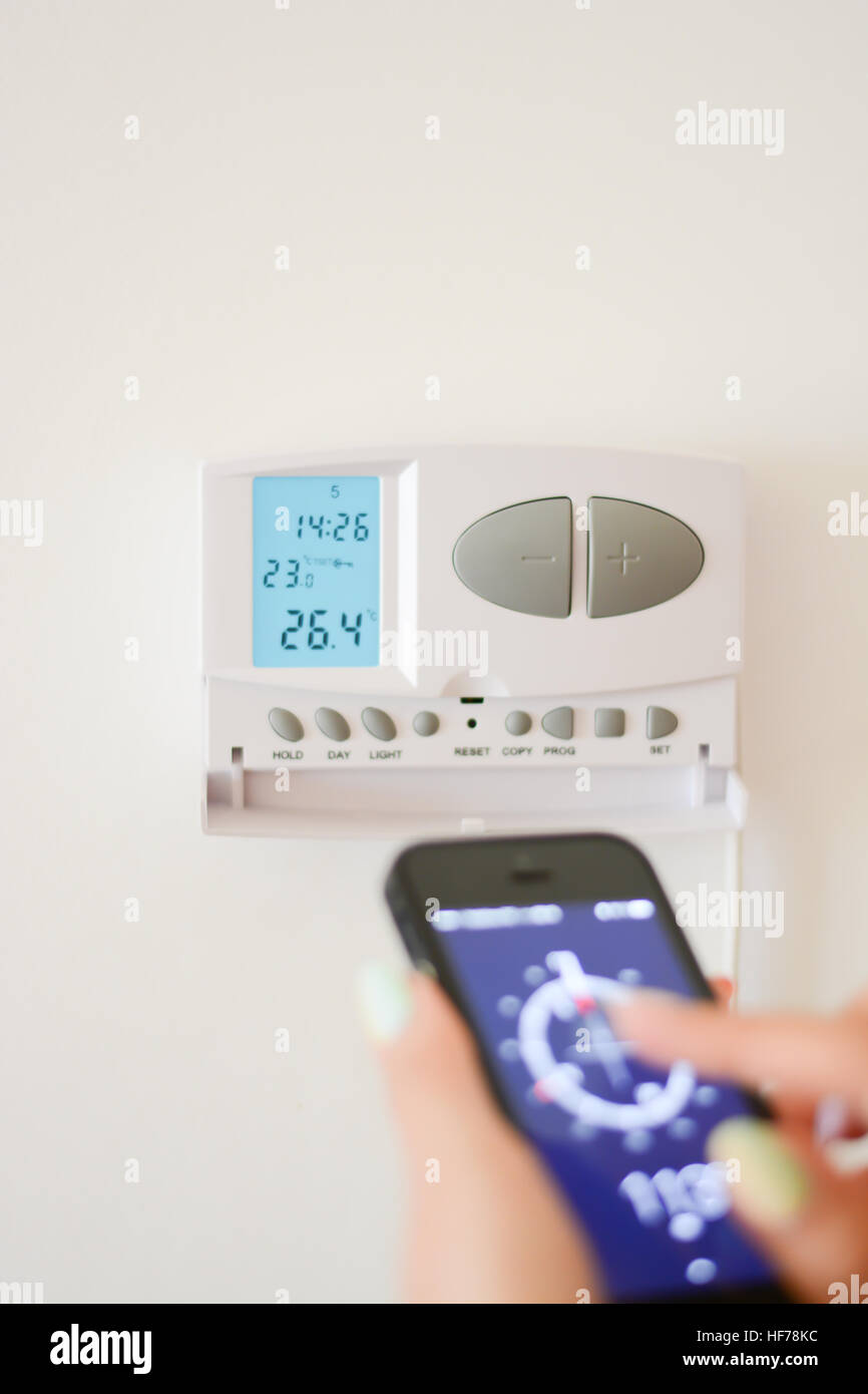 Adjust temperature in home interior with smartphone Stock Photo - Alamy