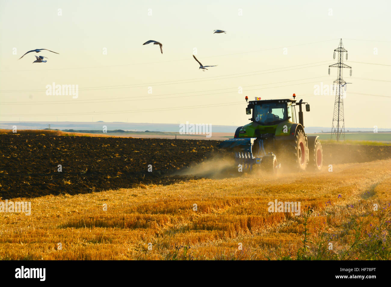 Modern farming with tractor in plowed field Stock Photo - Alamy