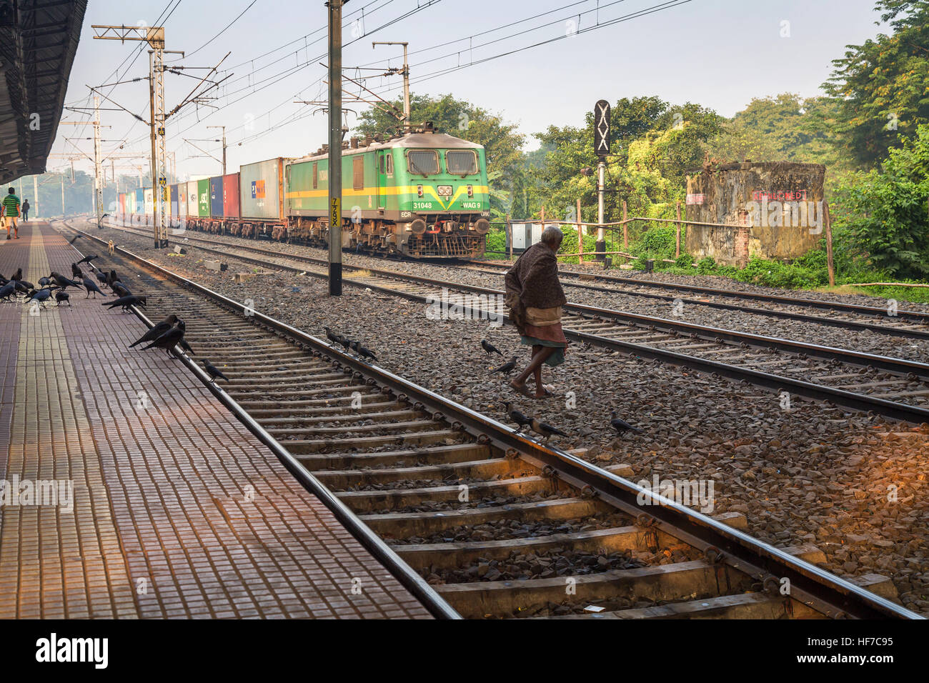 Old man tries to cross the railway tracks in front of a goods train at ...