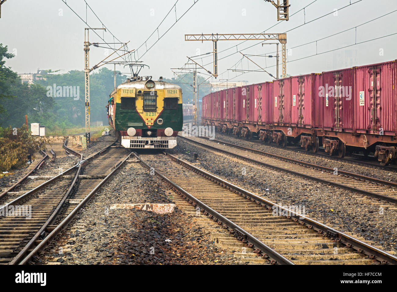 Crowded local passenger train of Indian railways about to enter a ...