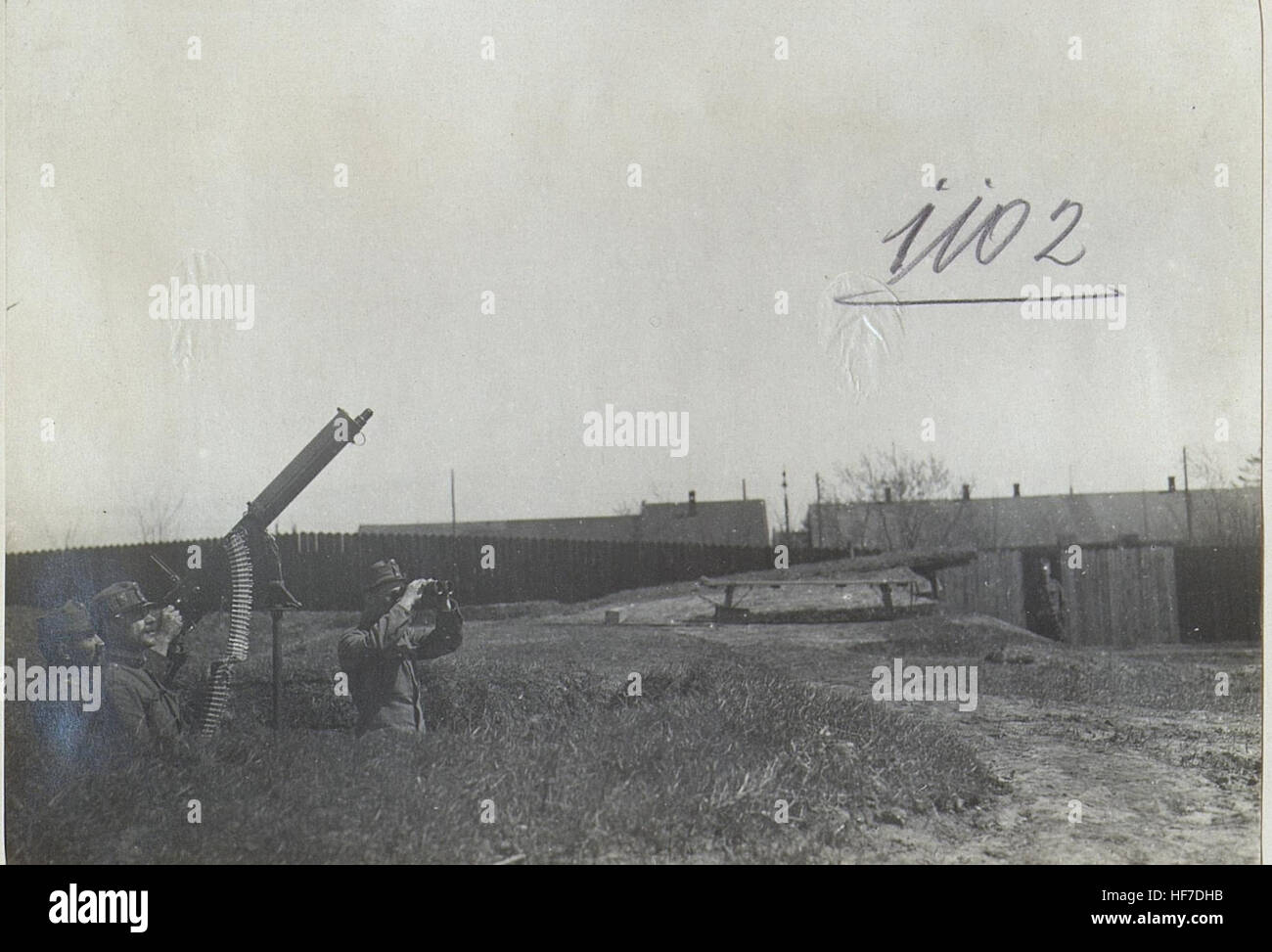 A German soldier stationed near a railway station with a machine gun ...