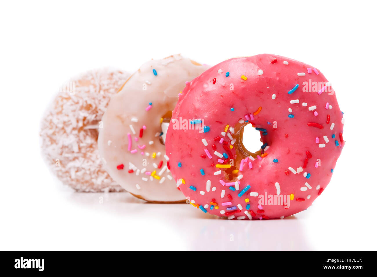 Three donuts isolated on White Background. Pink, Frosted and Coconut ...