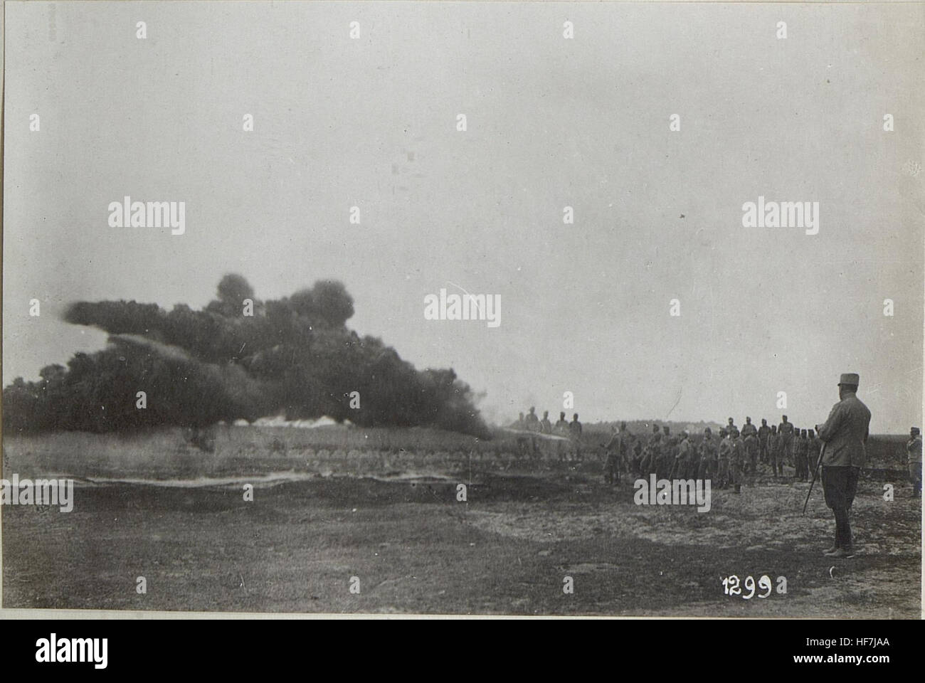 This historical image depicts a demonstration of a flamethrower, used ...