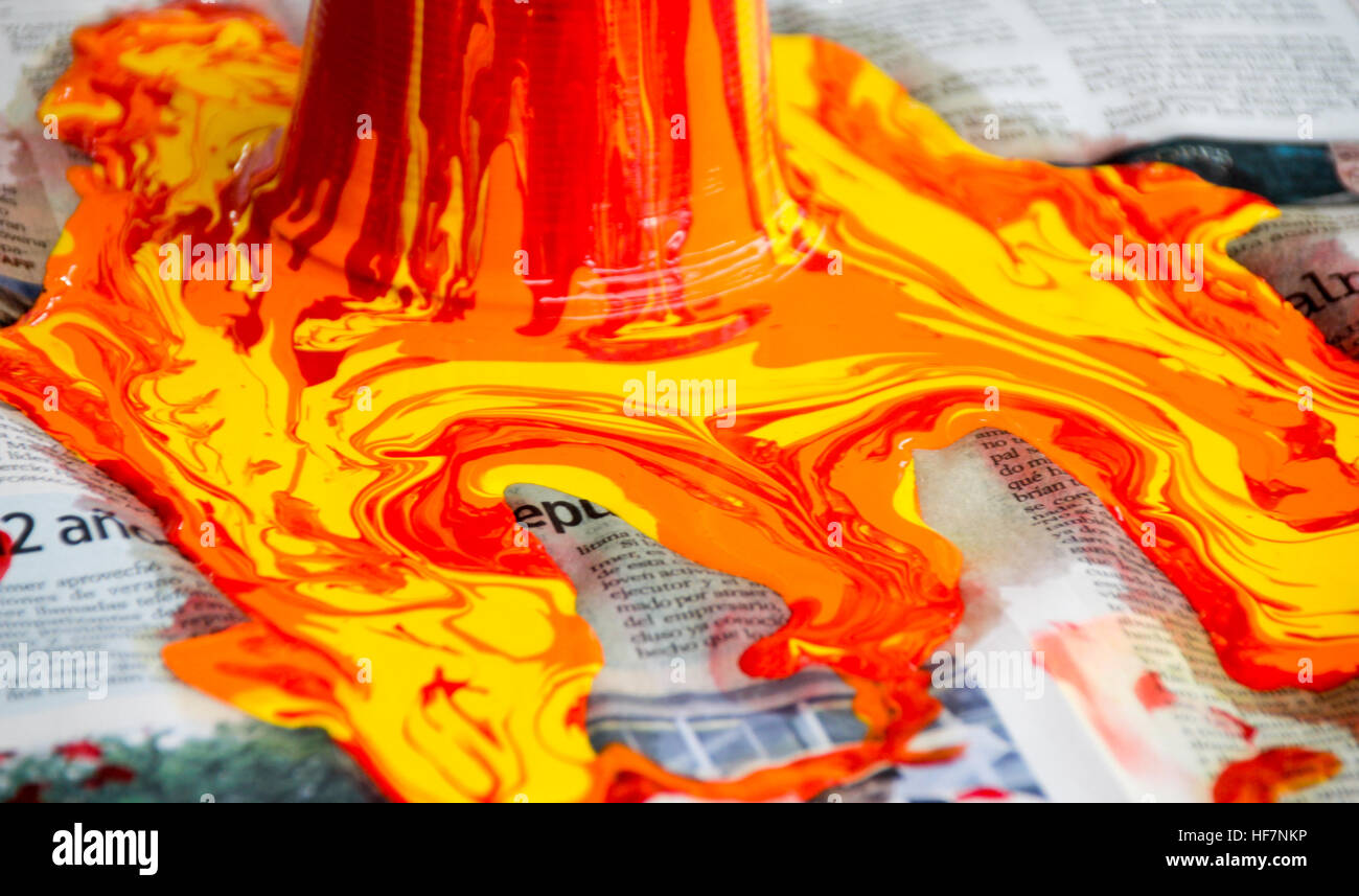 Photograph of some paint pouring out and spilling on a paper Stock ...