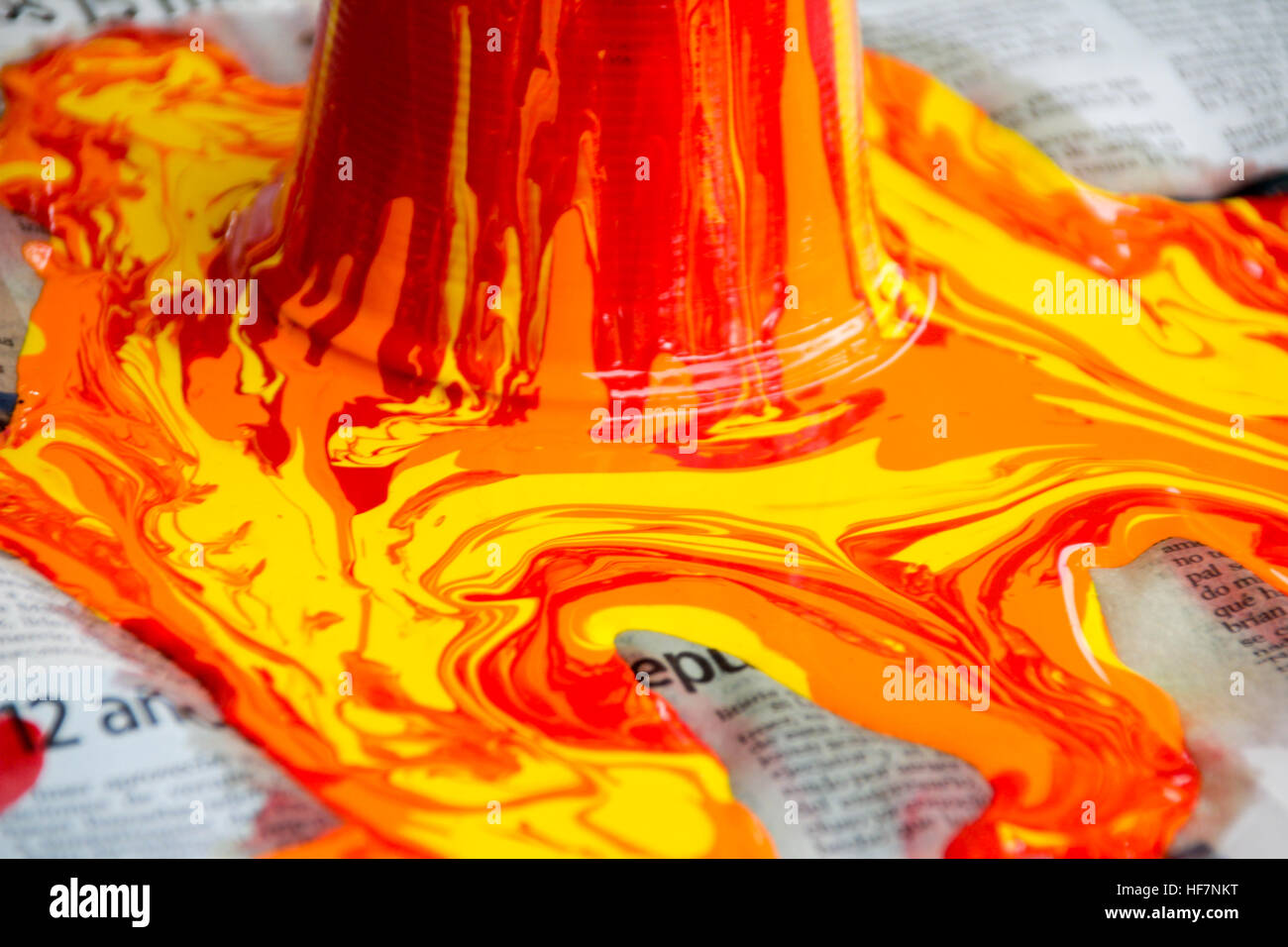 Photograph of some paint pouring out and spilling on a paper Stock ...
