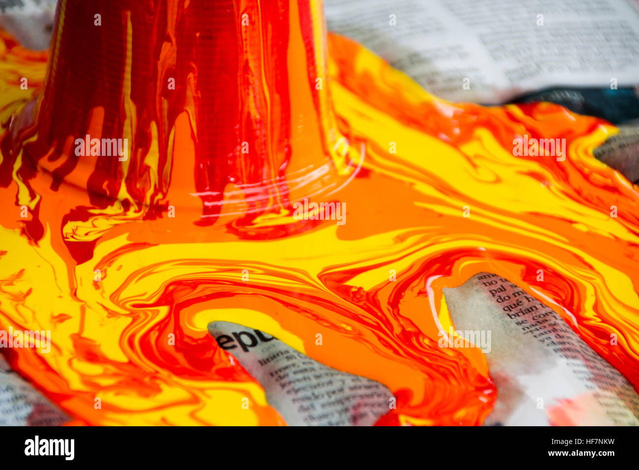 Photograph of some paint pouring out and spilling on a paper Stock ...