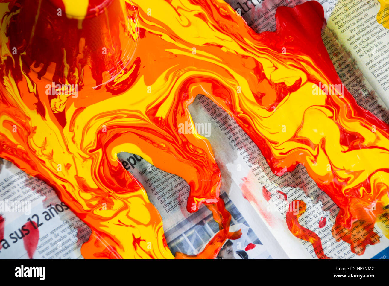 Photograph of some paint pouring out and spilling on a paper Stock ...