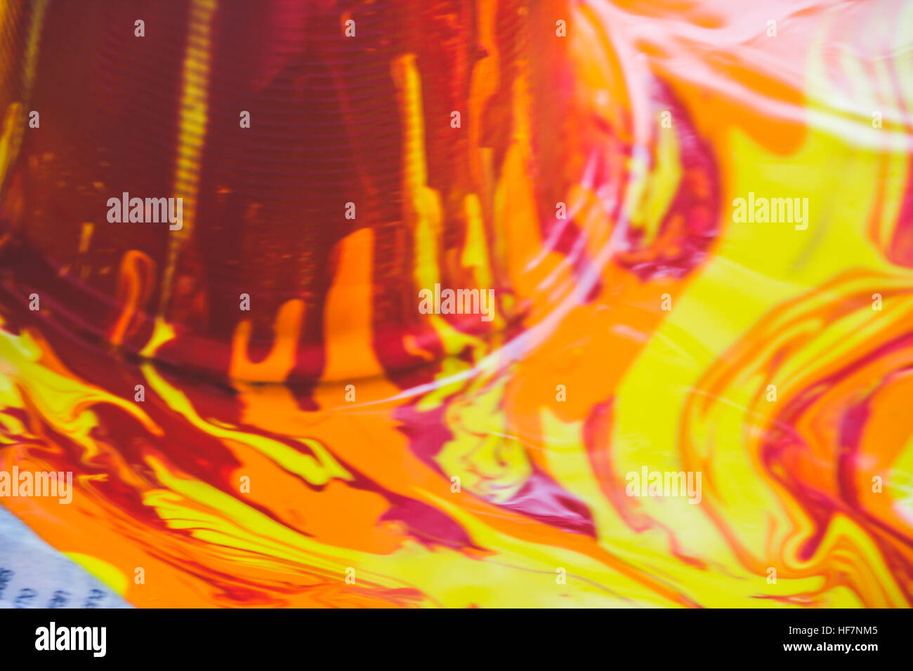 Photograph of some paint pouring out and spilling on a paper Stock ...