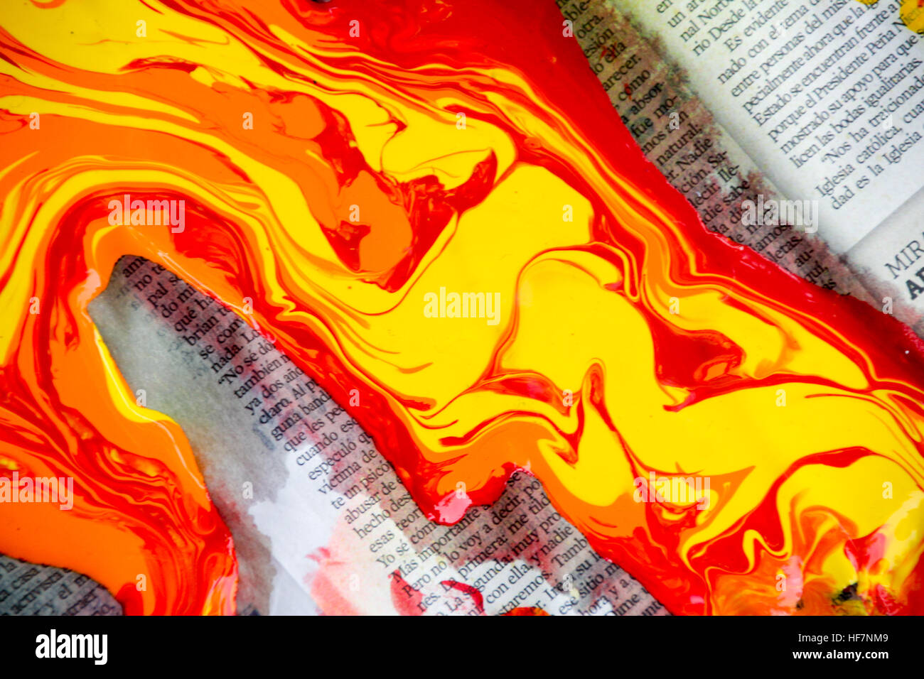 Photograph of some paint pouring out and spilling on a paper Stock ...