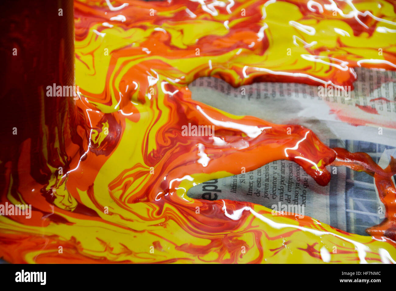 Photograph of some paint pouring out and spilling on a paper Stock ...