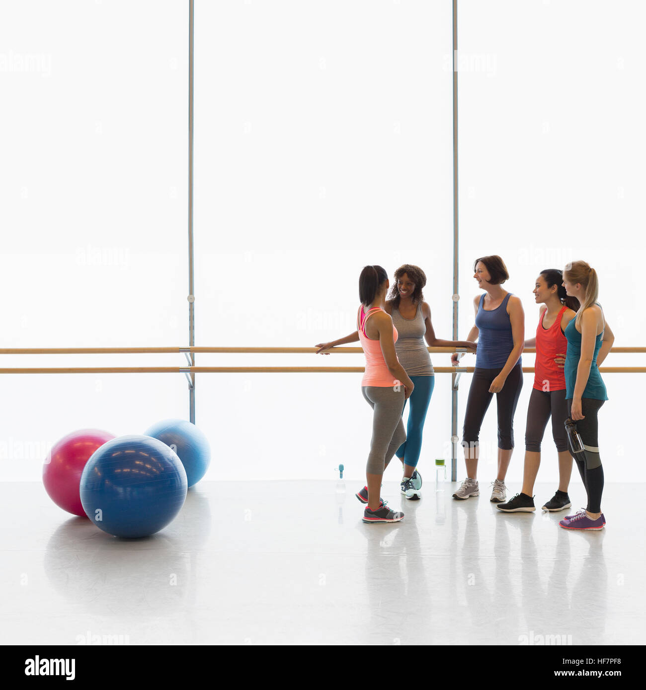 Women talking at barre in exercise class gym studio Stock Photo - Alamy