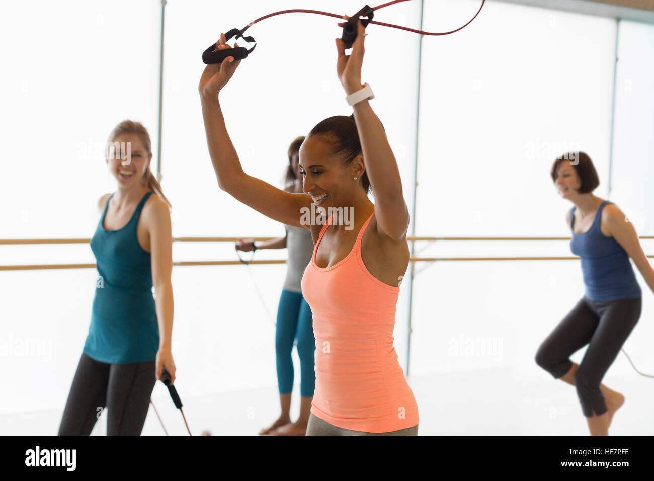 Smiling women jumping rope in exercise class gym studio Stock Photo - Alamy