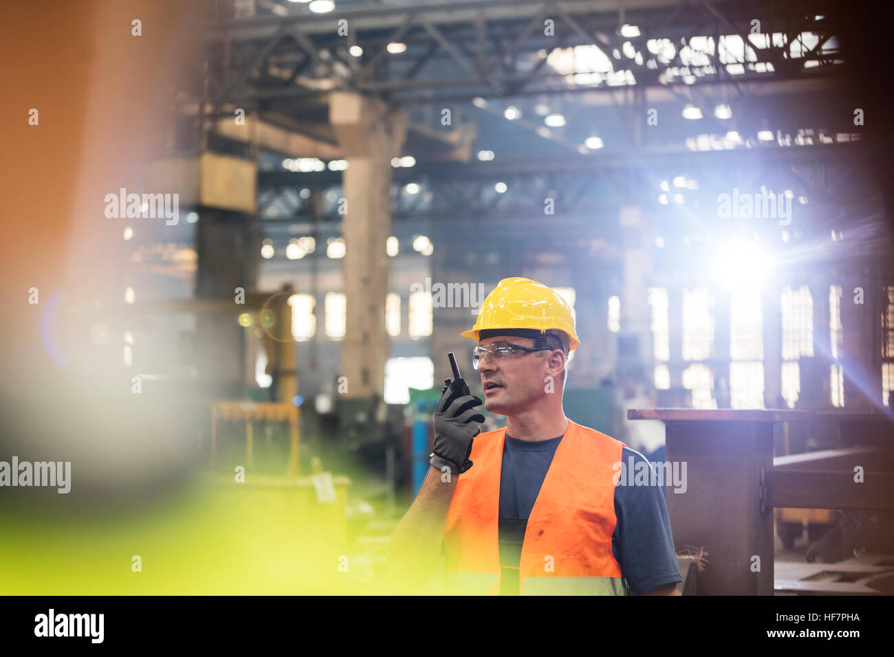 Steel worker using walkie-talkie in factory Stock Photo - Alamy