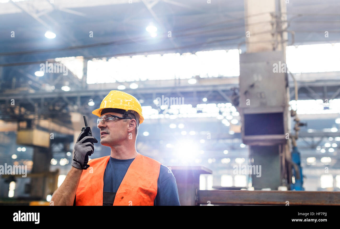 Steel worker using walkie-talkie in factory Stock Photo - Alamy