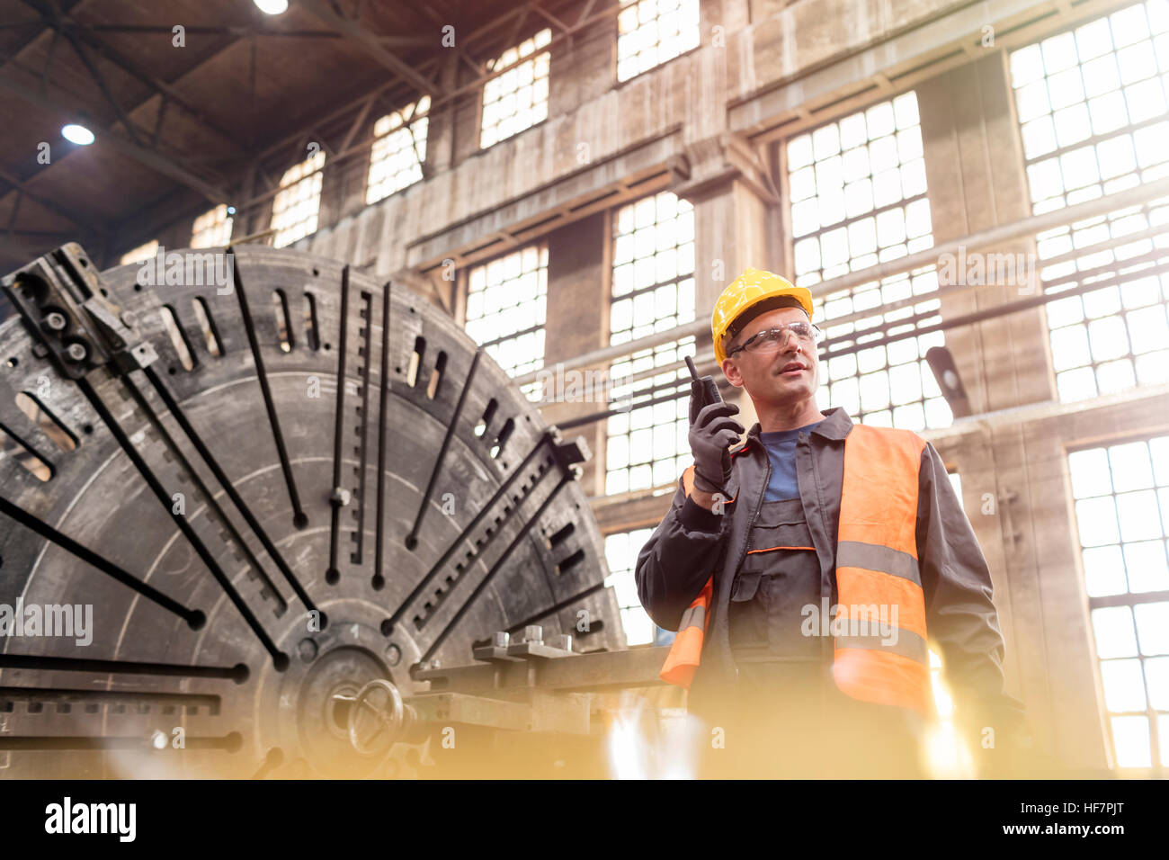 Steel worker using walkie-talkie in factory Stock Photo - Alamy