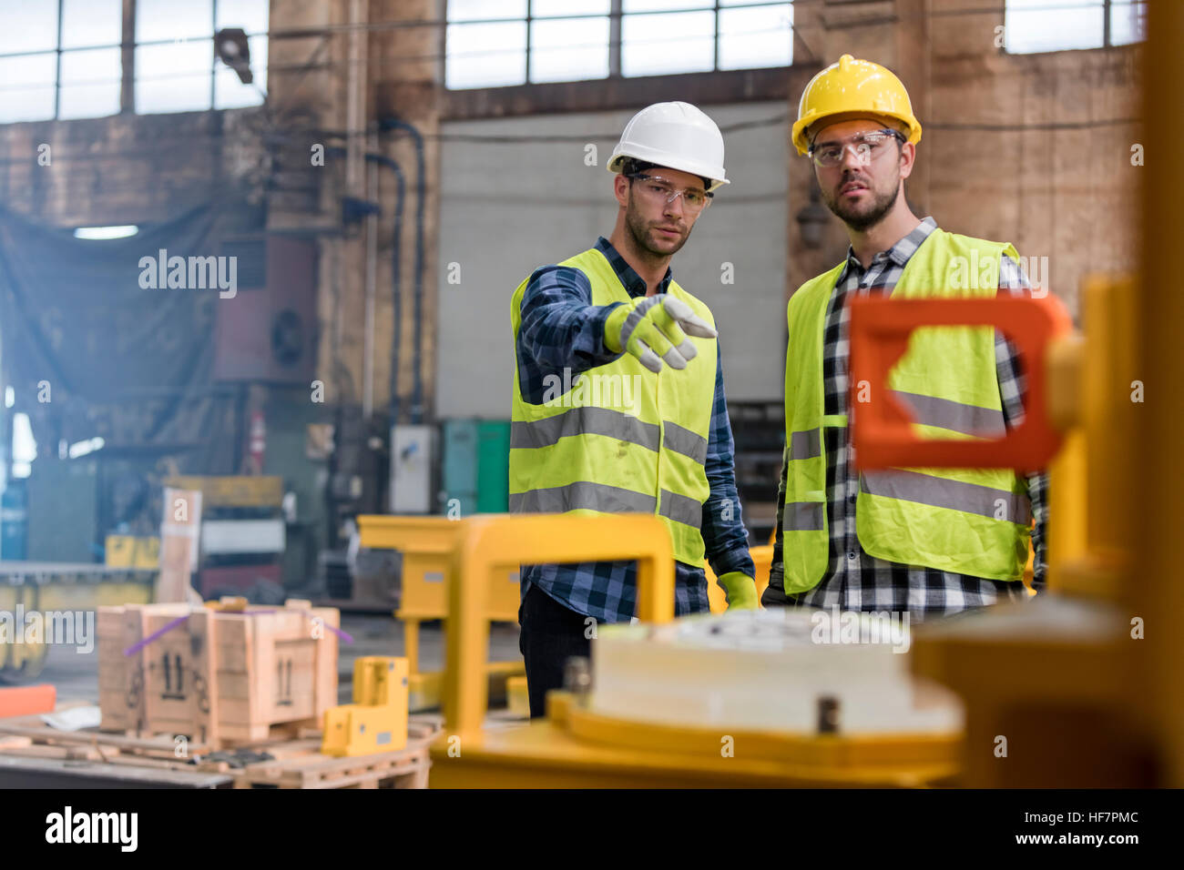 Steel workers talking and pointing in factory Stock Photo - Alamy