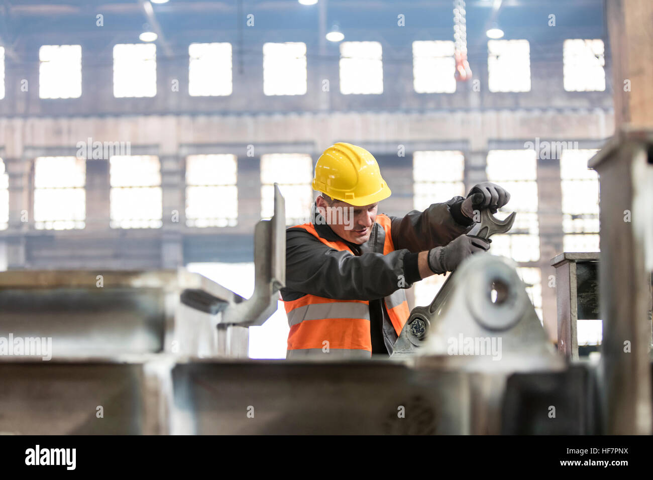 Steel worker using large wrench in factory Stock Photo - Alamy