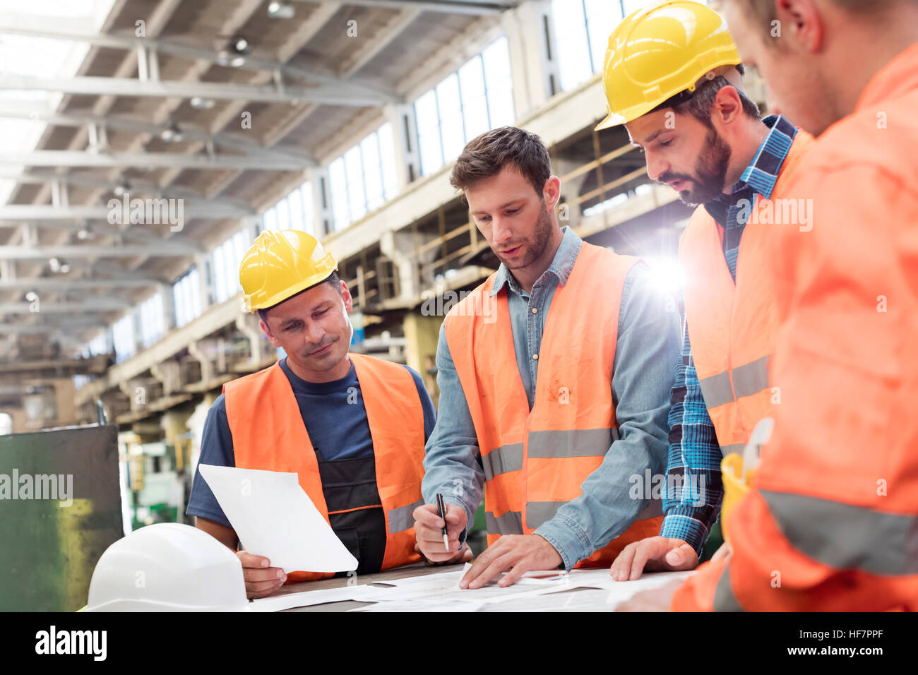 Steel workers and engineers meeting reviewing blueprints in factory ... Steel workers and engineers meeting reviewing blueprints in factory ...
