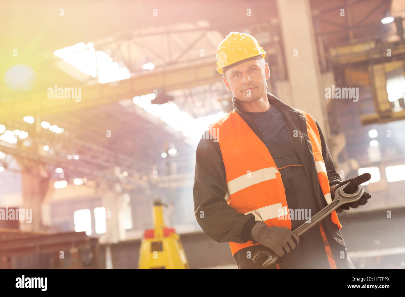 Portrait confident steel worker holding large wrench in factory Stock ...