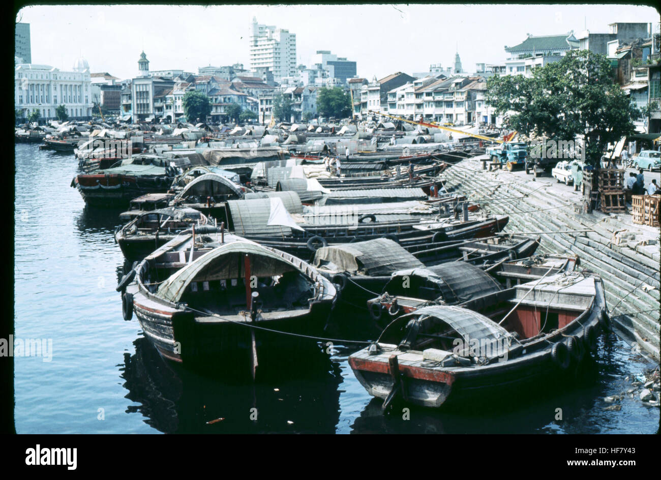 The photograph depicts sampans, traditional wooden boats, along the ...
