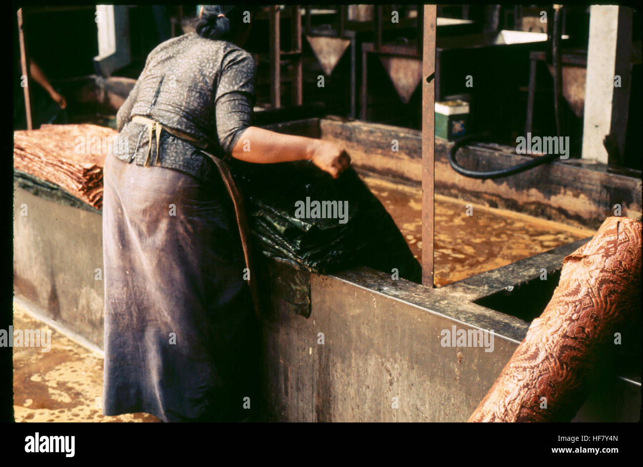 A woman is seen dyeing cloth in a batik factory located near Kuala ...