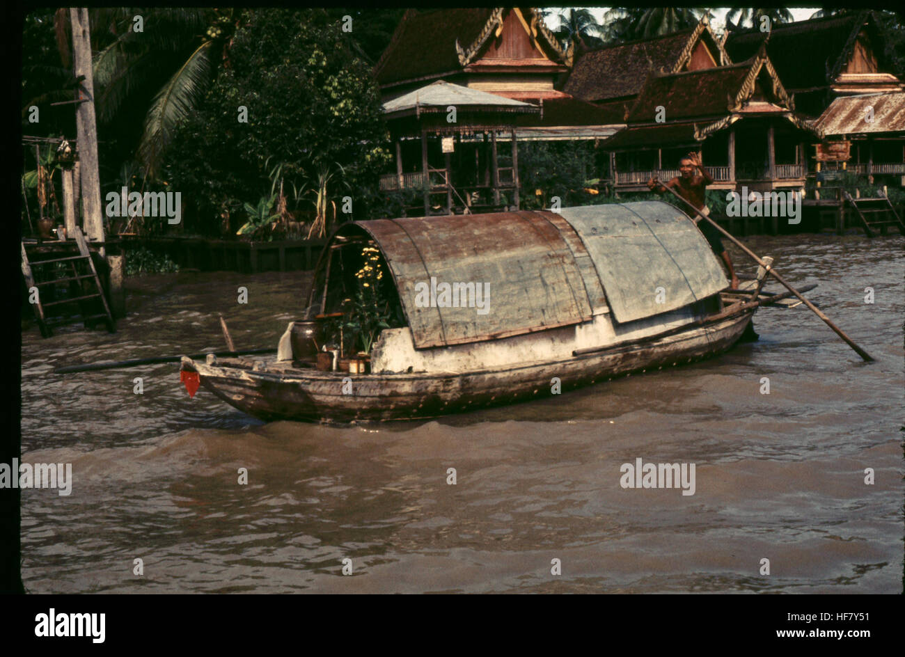 A traditional sampan boat is pictured navigating one of the canals in ...