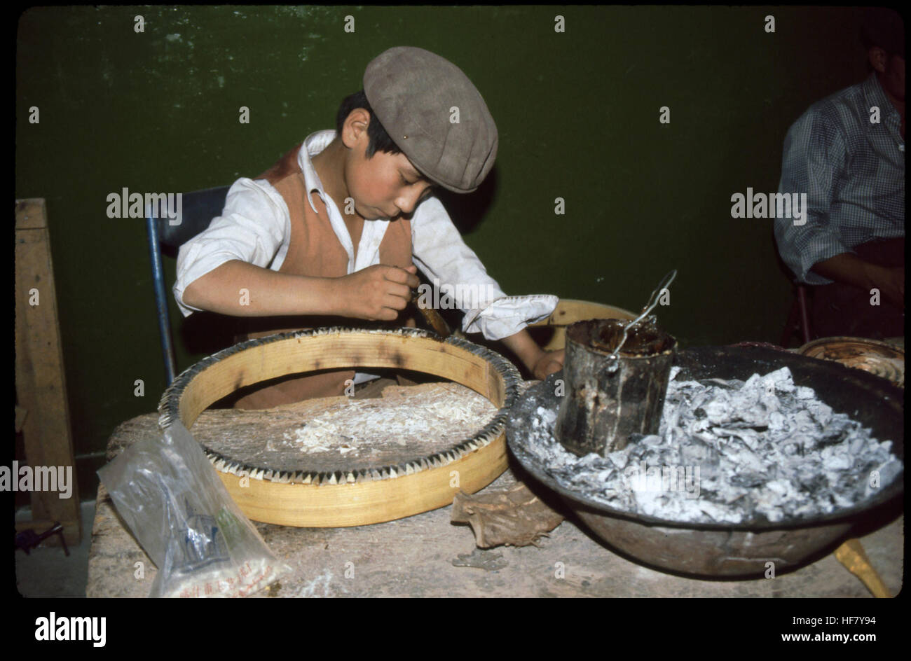 A photograph of a child working in a handicraft center in Kashgar ...
