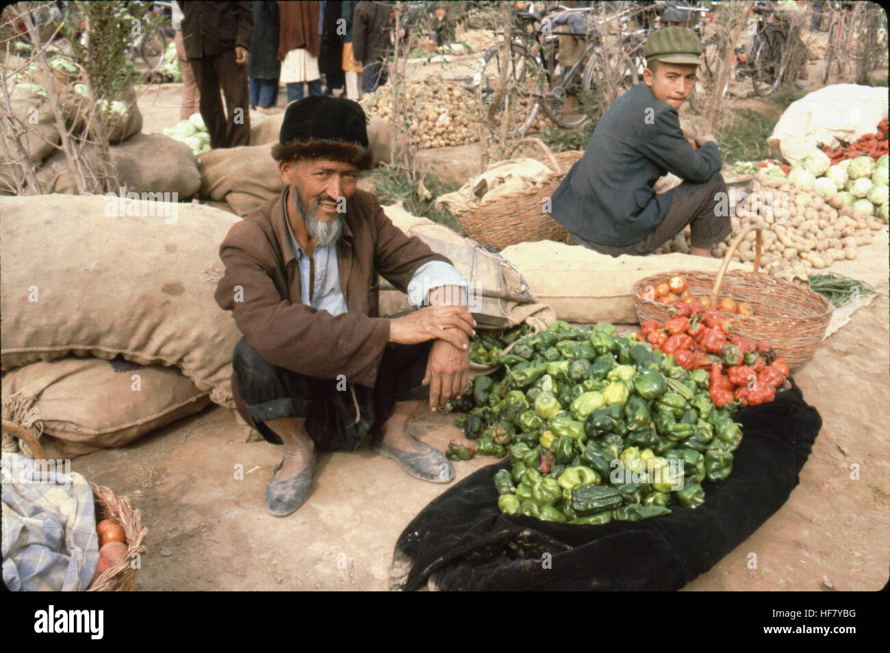 This photograph depicts two men trading vegetables at an open-air ...
