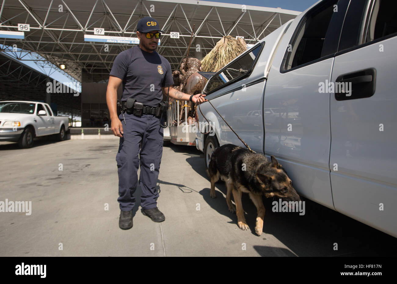 A U.S. Customs and Border Protection officer and his dog search a ...