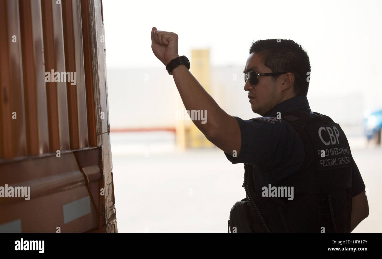A U.S. Customs and Border Protection officer signals for a truck driver ...