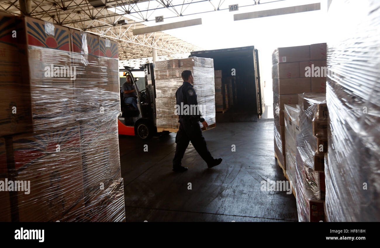 A U.S. Customs and Border Protection officer walks through pallets of ...