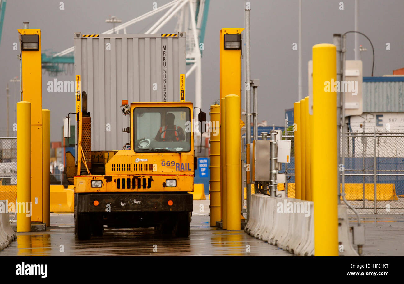 A shipping container pulled by a port vehicle arrives for scanning by ...