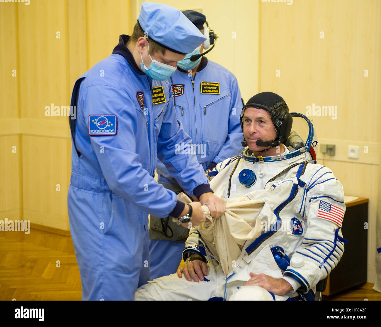 Expedition 49 flight engineer Shane Kimbrough of NASA is helped into ...