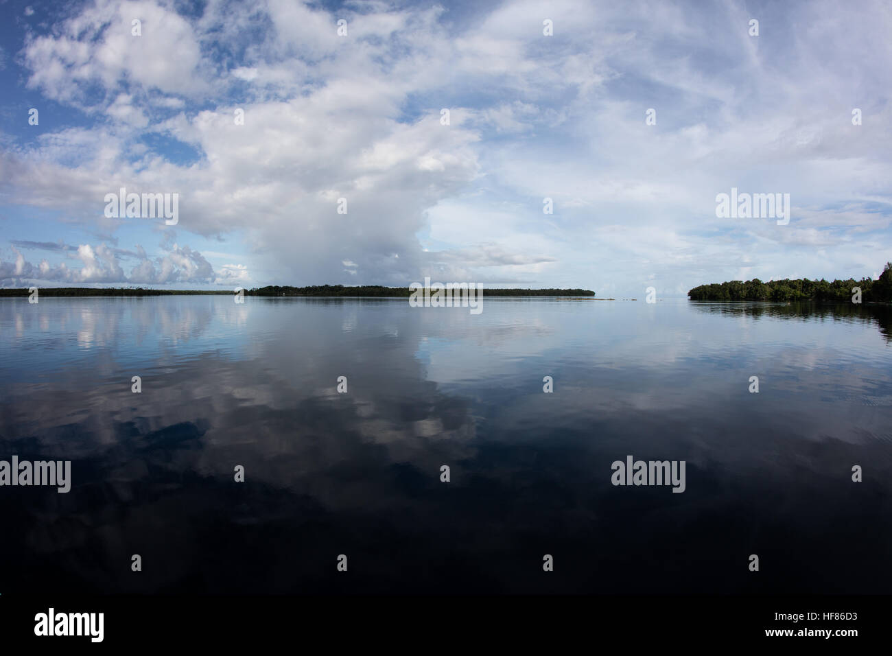 Calm water surrounds remote islands in the Solomon Islands. This region ...