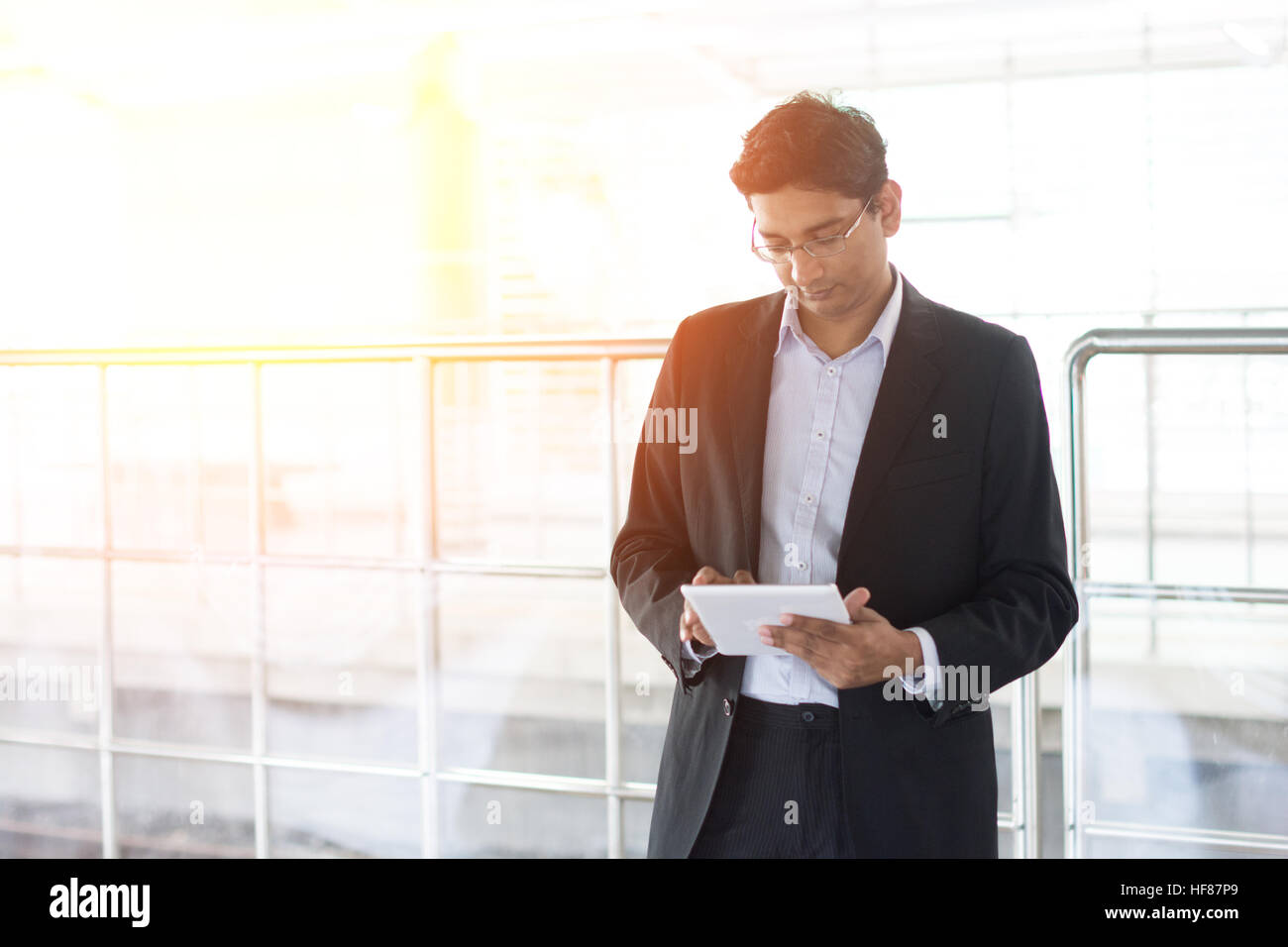 Asian Indian businessman using laptop computer while waiting train at ...