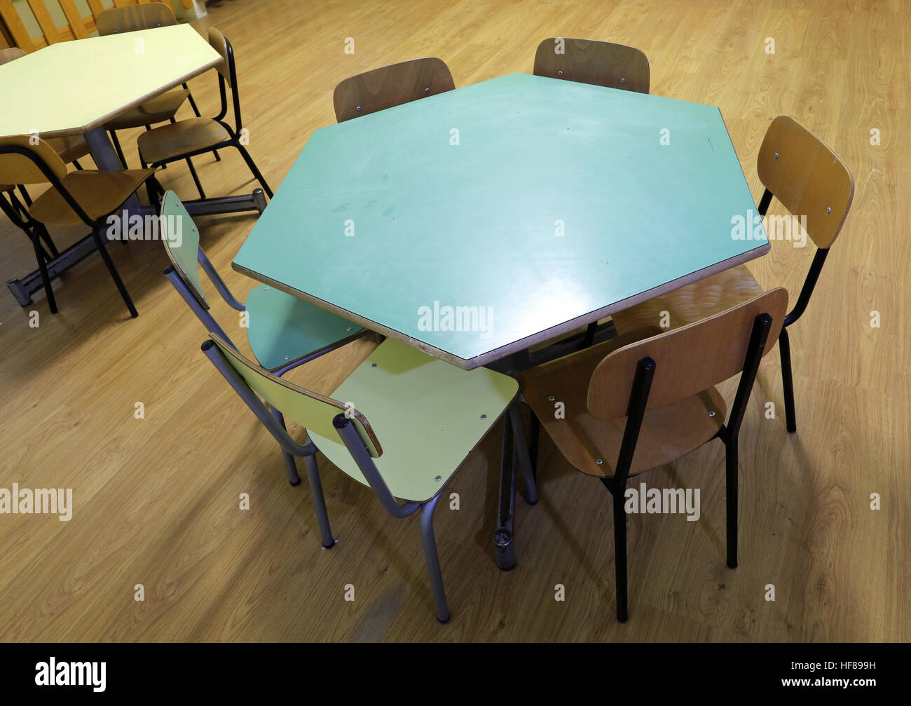 Hexagonal table with small chairs in a classroom with a parquet floor ...