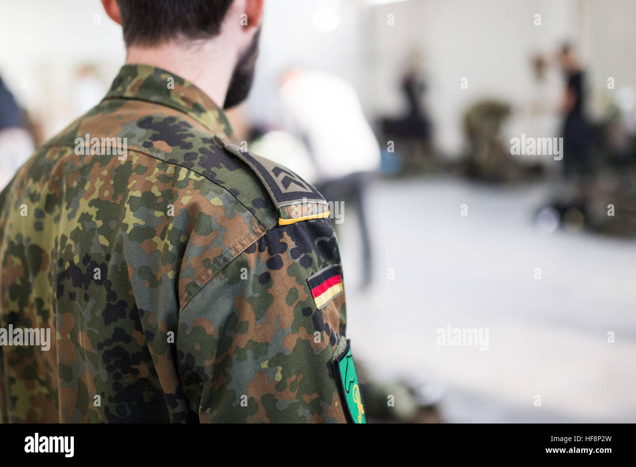 A German army soldier watches as new recruits receive army issued ...