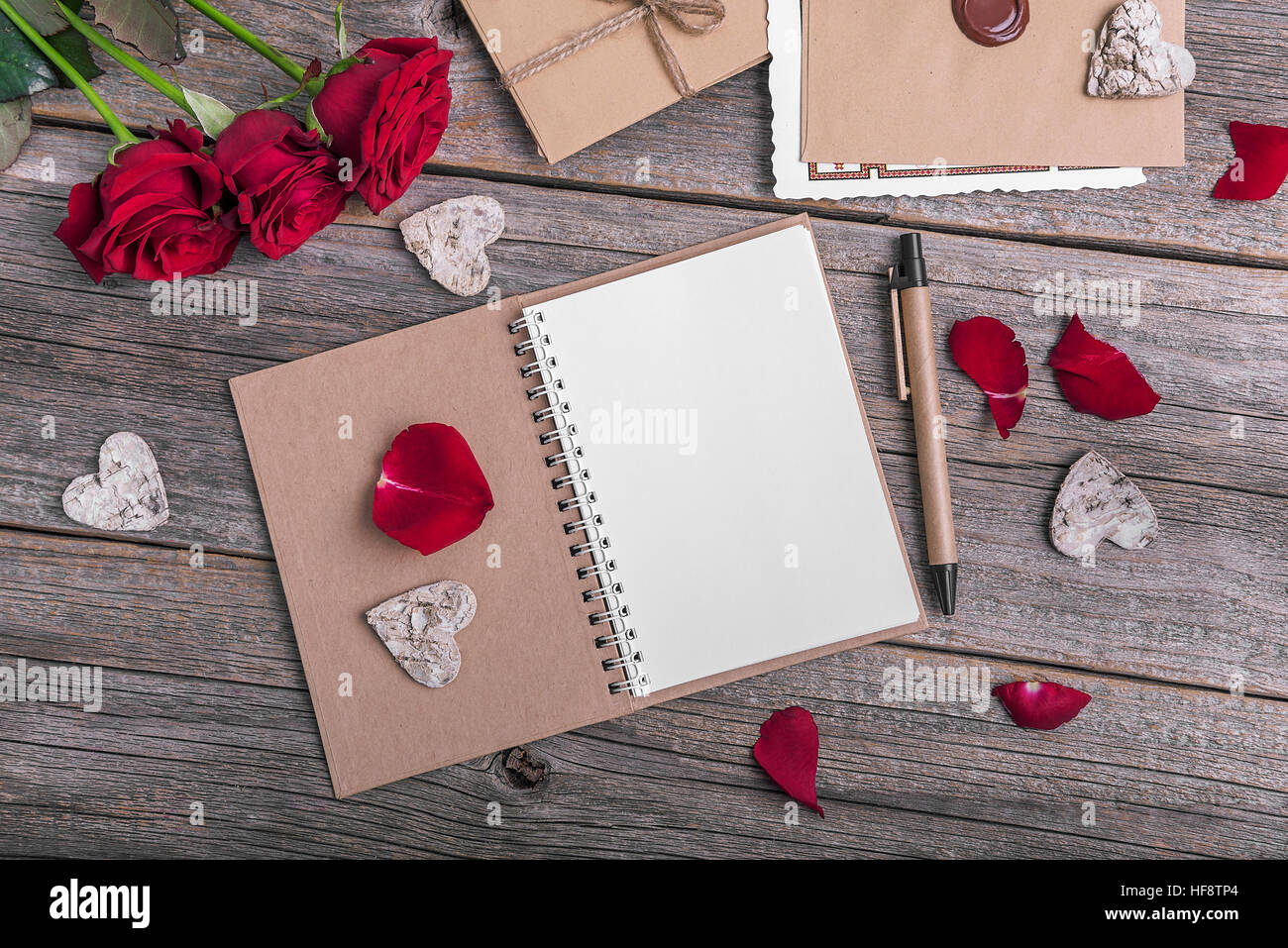Notebook and roses on a wooden background Stock Photo - Alamy