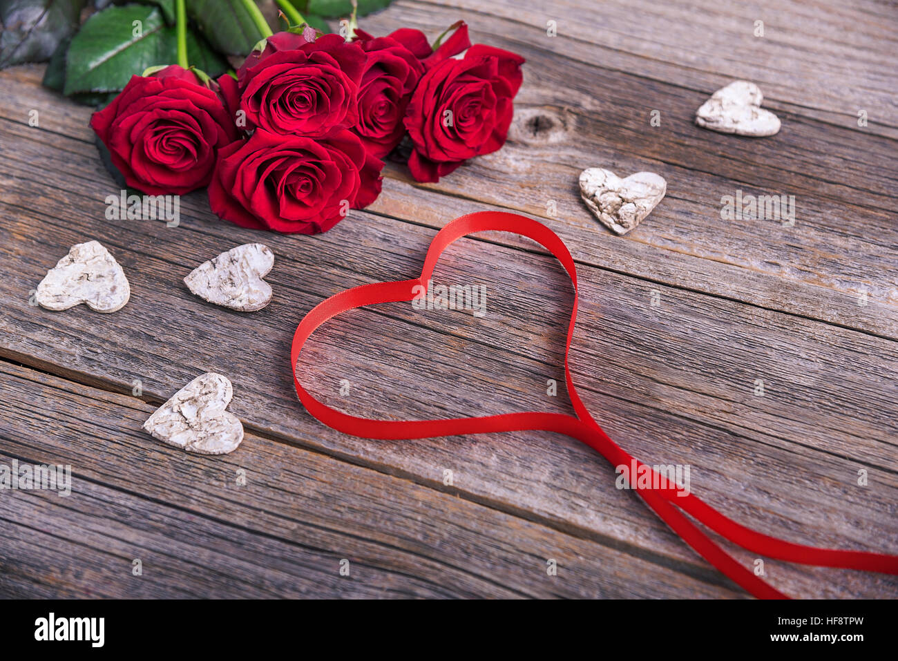 Red roses and heart on a wooden background Stock Photo - Alamy