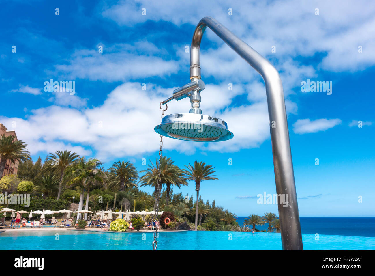 Detail view on the chrome made pool shower with ocean view pool in the ...