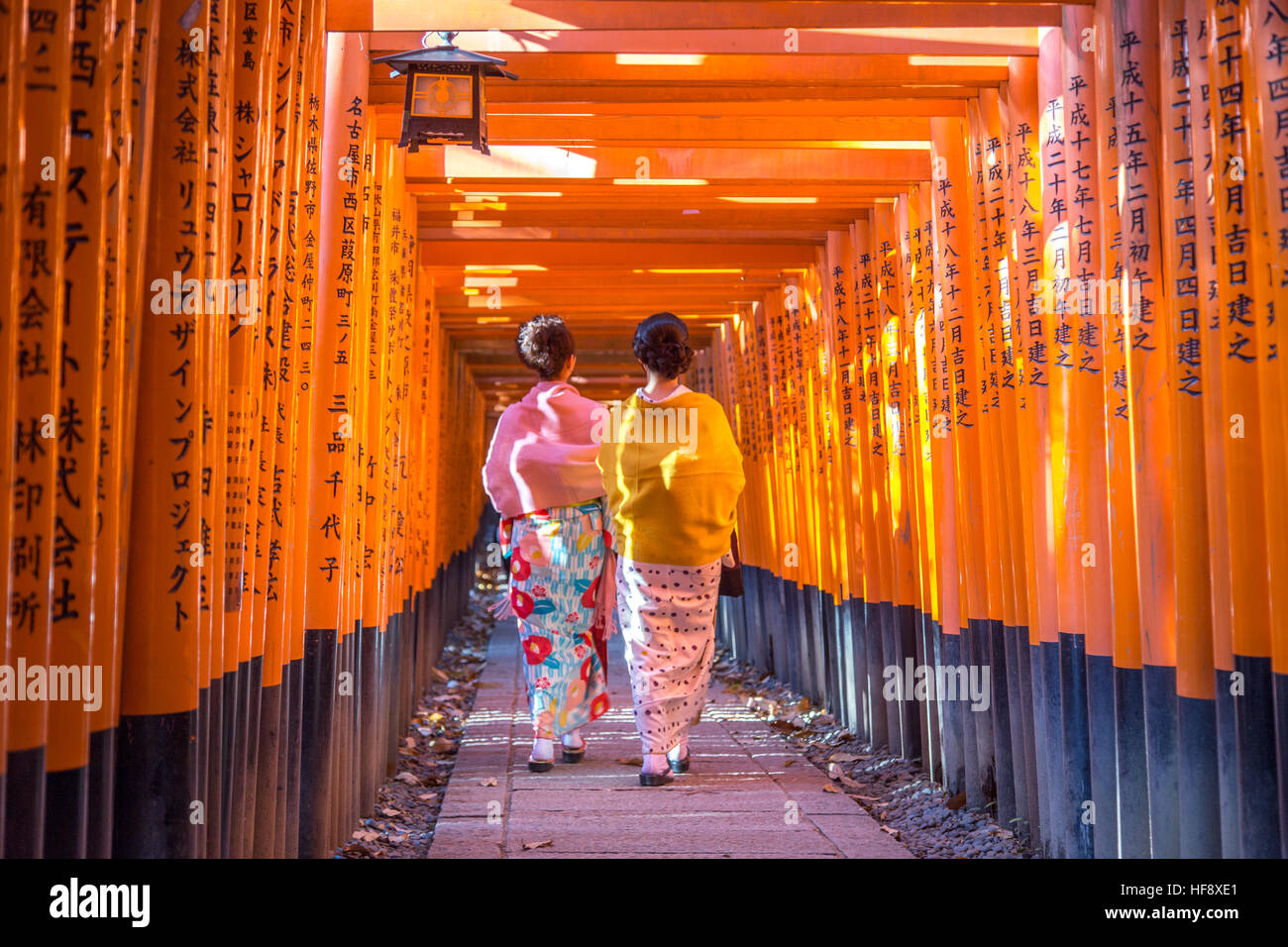 Kyoto, Japan - December 13, 2014: Two geishas walking through orange ...
