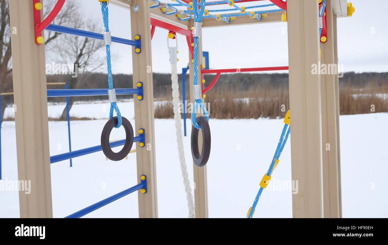 children playground gymnastic rings swing, snow landscape a winter ...