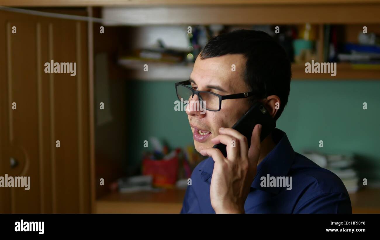 man with glasses talking on phone smartphone indoor Stock Photo - Alamy