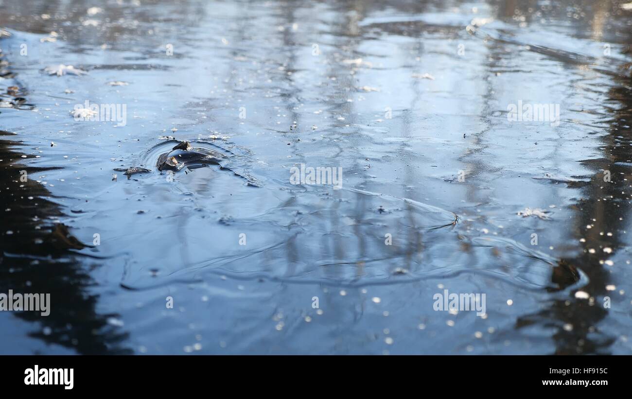 water flows through a hole in the ice end of winter landscape nature ...