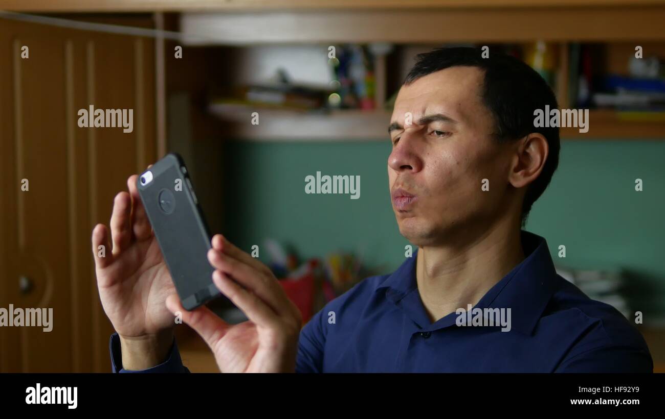 man makes a funny selfie phone smartphone indoor Stock Photo - Alamy